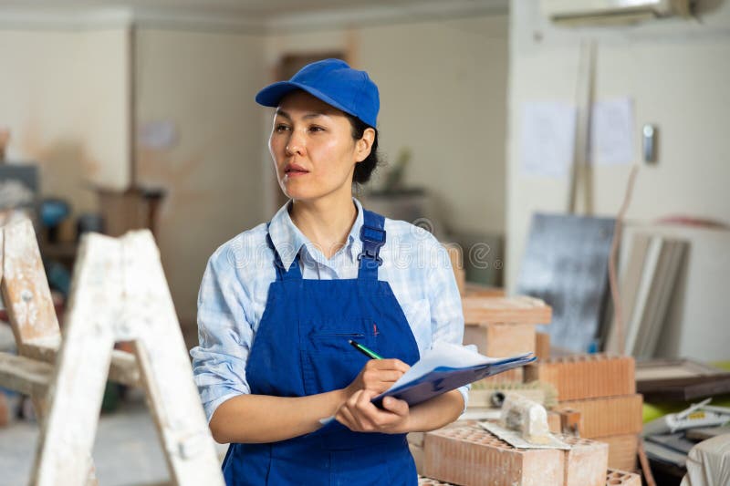 Female Builder Fills Out Documentation during Repair Work Stock Photo ...