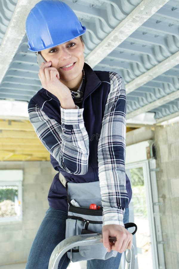 Female Builder on Stepladder Taking Call on Smartphone Stock Photo ...