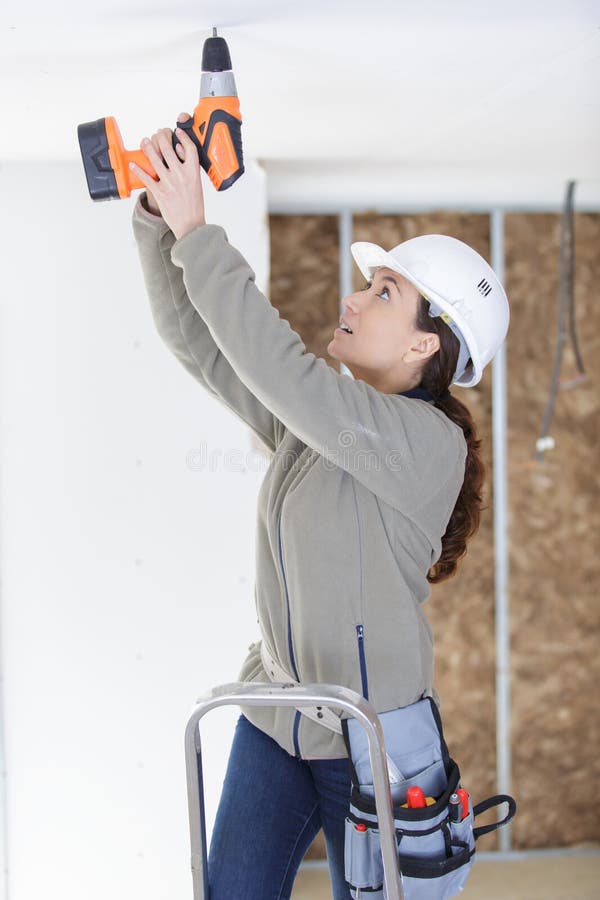 Female Builder Using Cordless Drill Overhead Stock Image - Image of ...