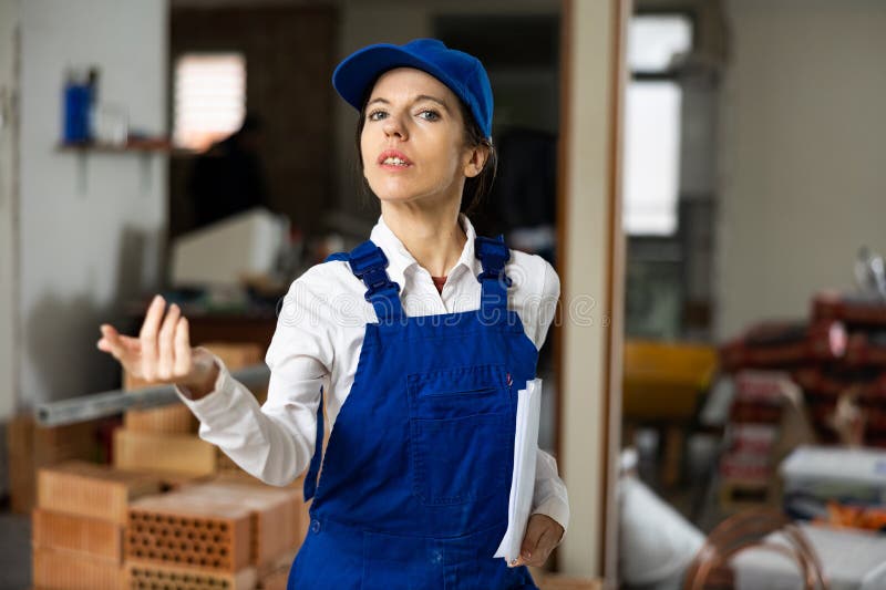 Female Builder Wearing Overalls and Cap Posing at Construction Site ...