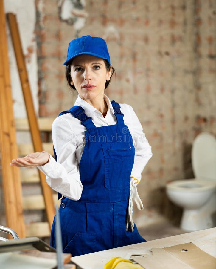 Female Builder Wearing Overalls and Cap Posing at Construction Site ...