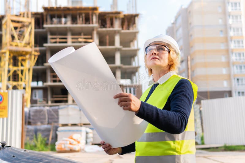 A Female Builder Worker at a Construction Site Works and Controls the ...