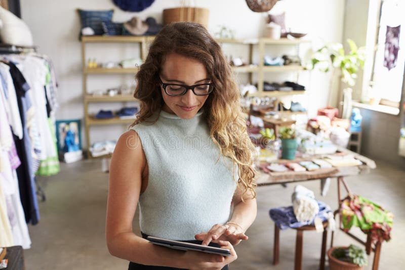 Female Business Owner Using Tablet Computer in Clothes Shop Stock Photo ...