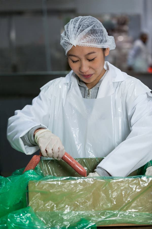 Female Butcher Processing Sausages Stock Photo - Image of happy ...