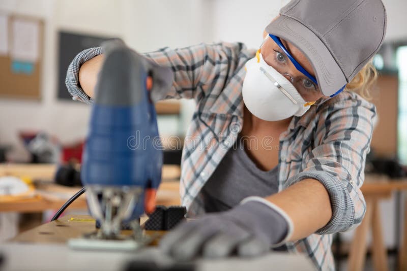 Female Carpenter Cutting Wood Using Power Saw Stock Photo - Image of ...