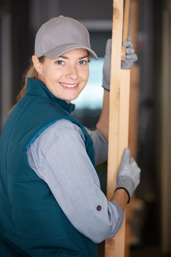 Female Carpenter Holding Wood Planks at Construction Site Stock Photo ...
