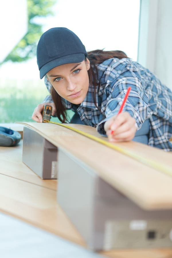 Female Carpenter Measuring Wood Board in Workshop Stock Image - Image ...