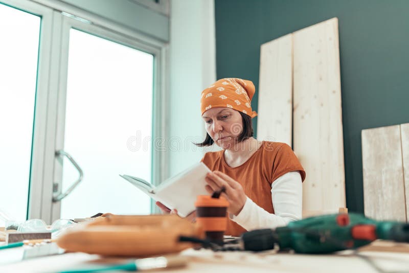 Female Carpenter Reading DIY Project Instruction Manual Stock Image ...