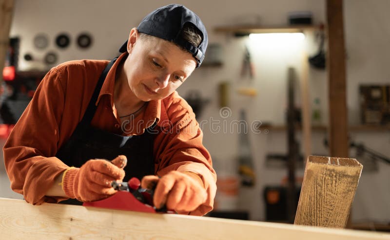 Female Carpenter Using Carpentry Tool Planing a Plank of Wood with a ...