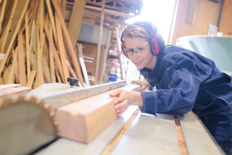 Female Carpenter Using Table Saw To Cut Wood in Workshop Stock Photo ...