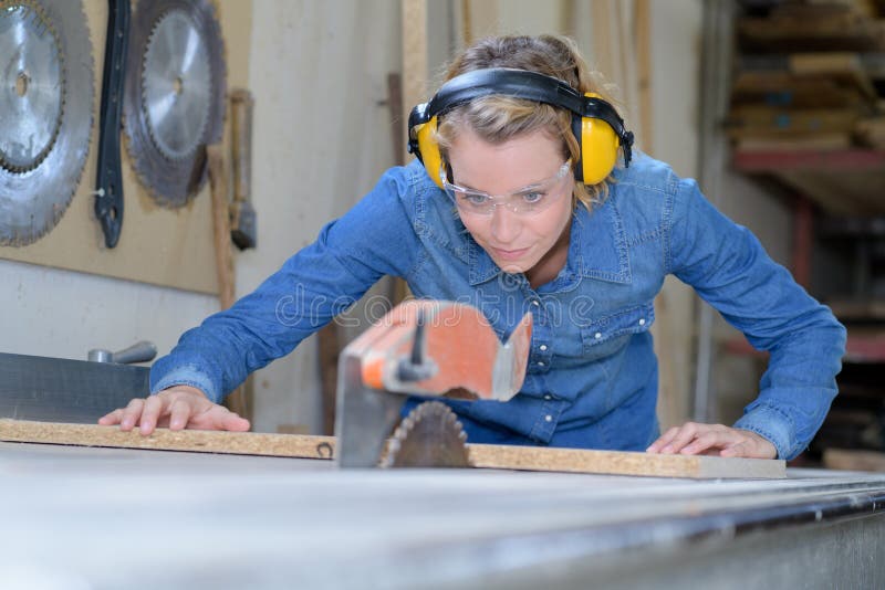 Female Carpenter Wearing Earmuffs and Using Table Saw Stock Image ...