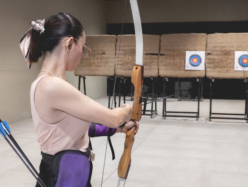 A Female Casual Hobbyist Doing Target Practice at an Indoor Archery ...