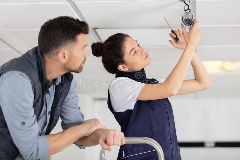 Female Cctv Installer Hinstalling Security Camera Stock Photo - Image ...