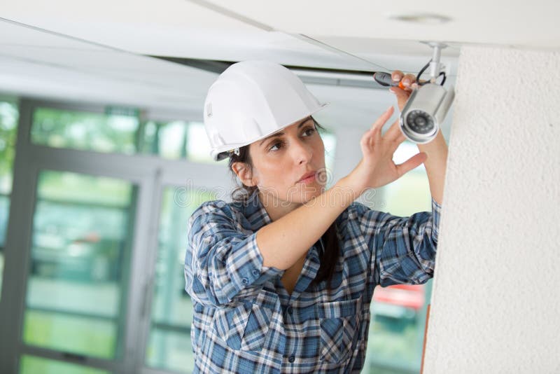Female Cctv Installer Hinstalling Security Camera Stock Photo - Image ...