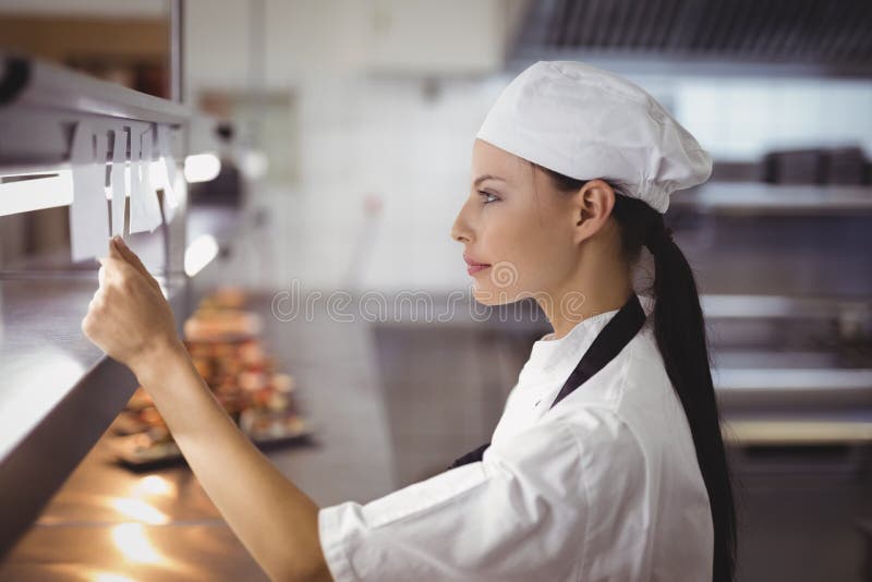Female Chef Looking at an Order List in the Commercial Kitchen Stock ...