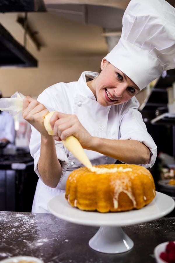 Female Chef Piping a Cake in Kitchen Stock Photo - Image of chefs ...
