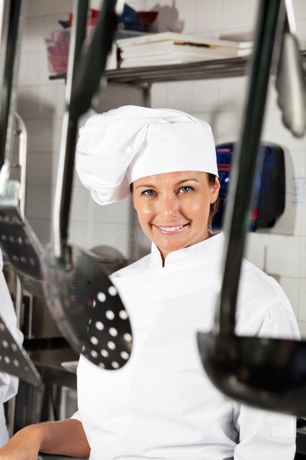 Female Chef with Spoons Hanging in Foreground Stock Photo - Image of ...
