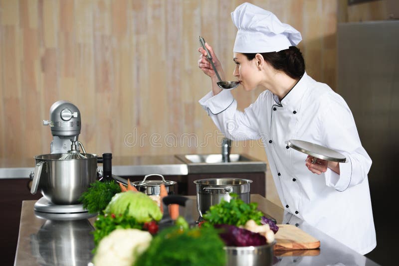 Female chef tasting dish stock image. Image of taste - 127721401
