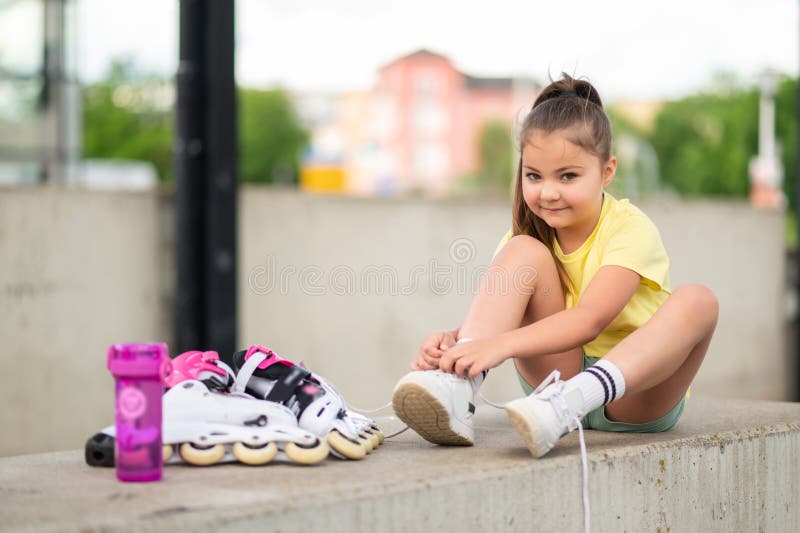 Female Child Putting on Roller-blades Getting Ready for Energetic Play ...
