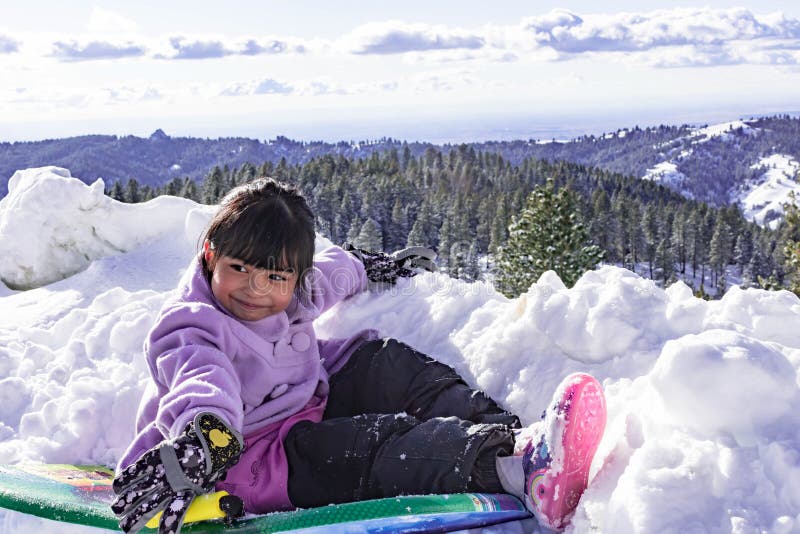 Female Child while Sitting on a Snow Board and Playing with Snow Stock ...