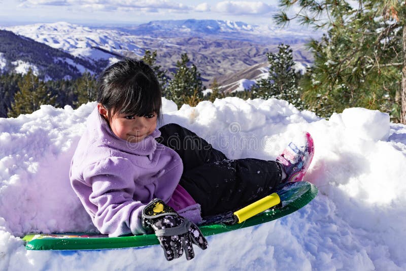 Female Child while Sitting on a Snow Board and Playing with Snow Stock ...
