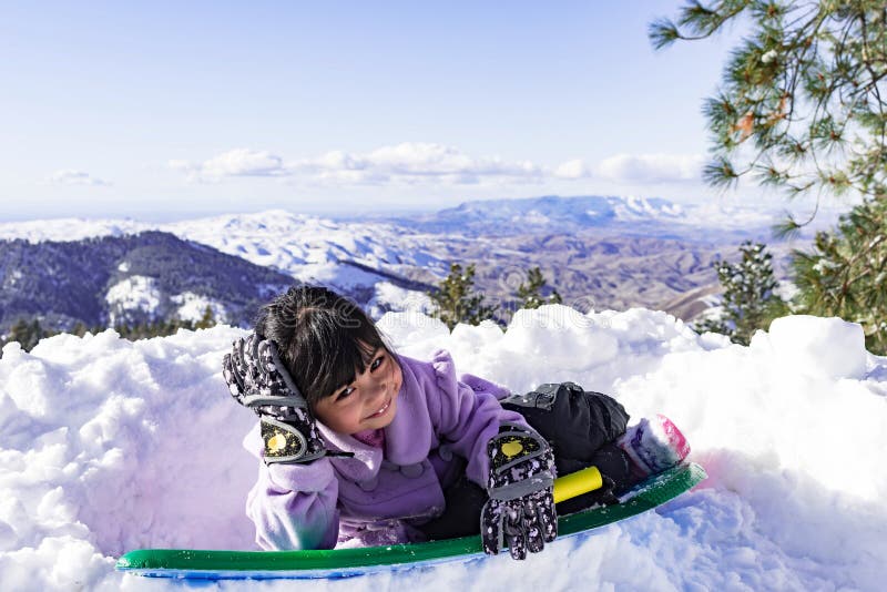 Female Child while Sitting on a Snow Board and Playing with Snow Stock ...
