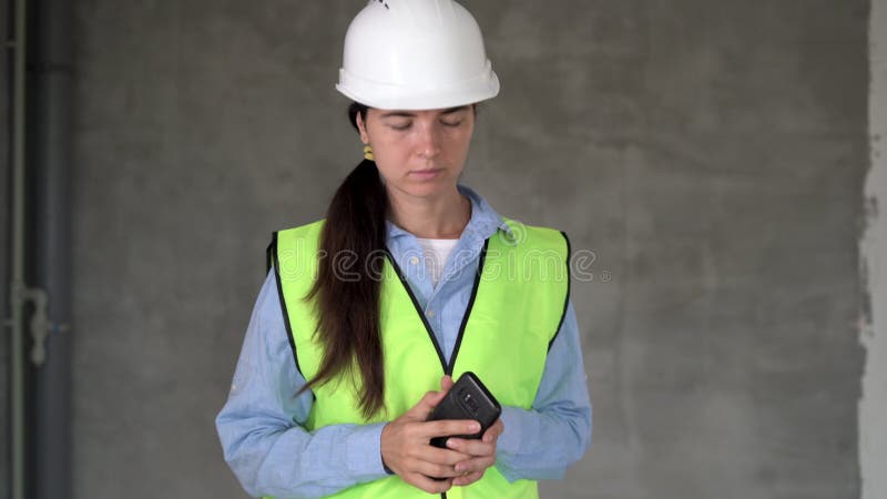 Female Civil Engineer Working Using Smartphone at Construction Site ...