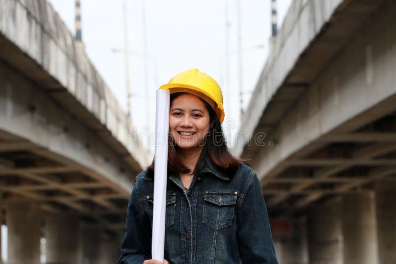 Female Civil Engineer with Yellow Helmet, Standing with Project Drafts ...