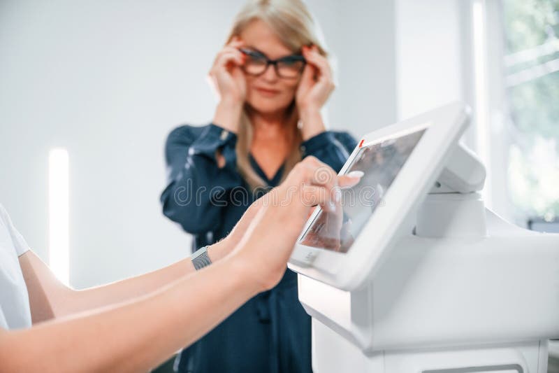 Female Clinic Worker Setting Up Special Device for Vision Test. Female ...