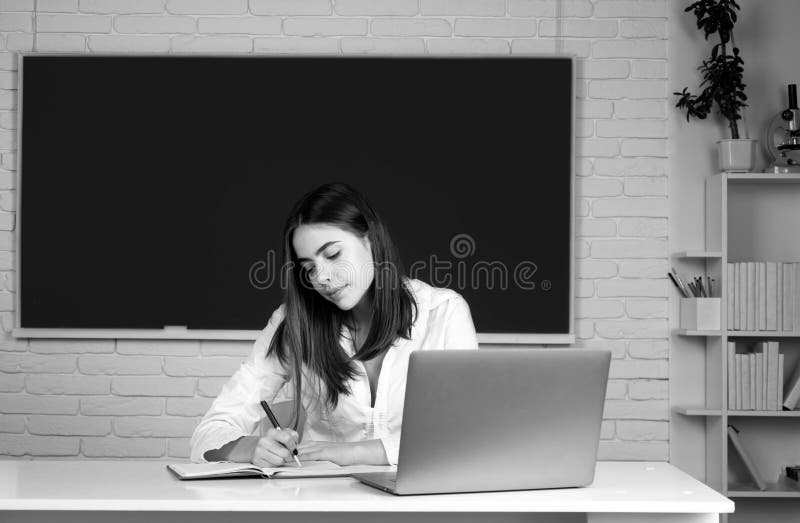 Female College Student Working on a Laptop in Classroom, Preparing for ...