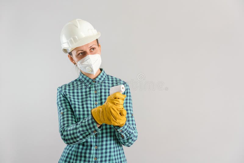 A Female Construction Worker in a Helmet Checks the Temperature with an ...