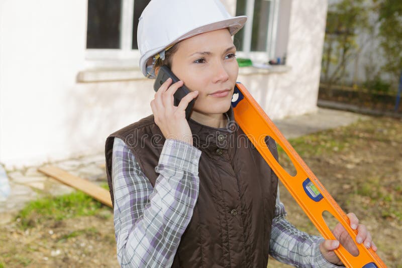 Female Construction Worker with Level Outside Construction Site Stock ...
