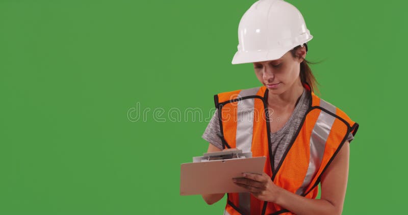 Female Construction Worker Writing Notes on Clipboard on Green Screen ...