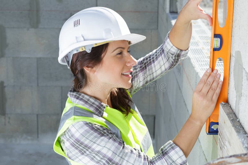Female Constructor Working with Level on Wall Stock Photo - Image of ...