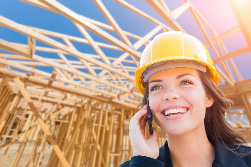 Female Contractor in Hard Hat Using Cell Phone at Construction Site ...