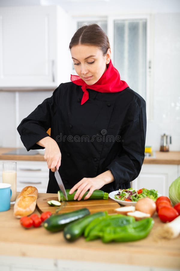 Female Cook in Black Uniform Chopping Vegetables in Kitchen Stock Photo ...
