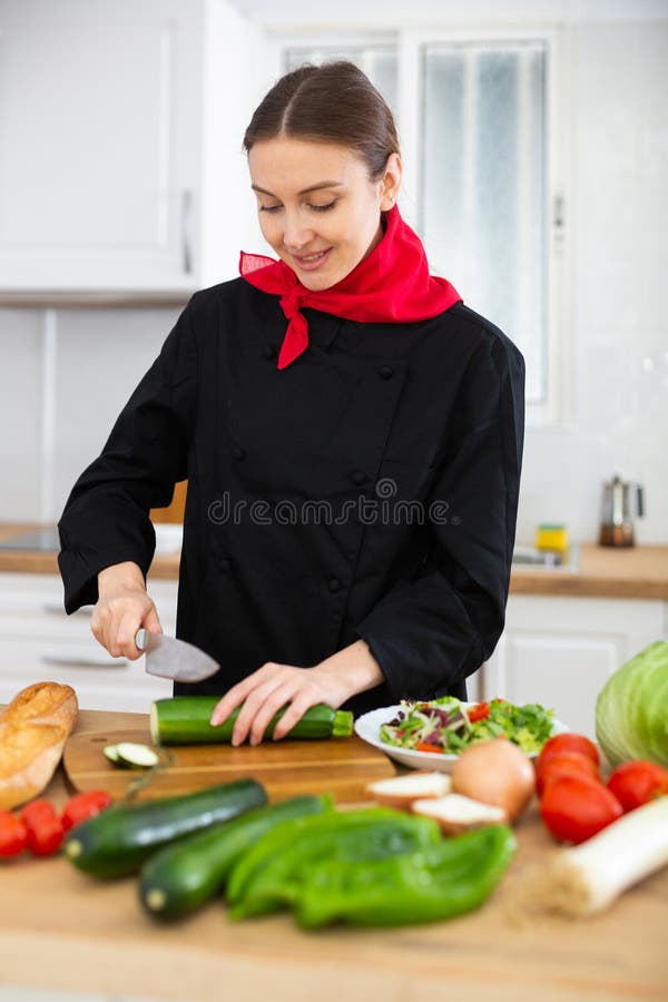 Female Cook in Black Uniform Chopping Vegetables in Kitchen Stock Photo ...