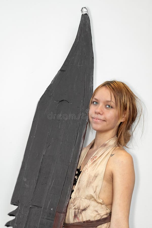 Female Cosplayer in a Horror Outfit Posing with a Large Blade Sword on ...