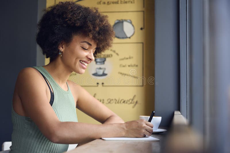 Female Customer in Coffee Shop Window Working Writing in Notebook Stock ...