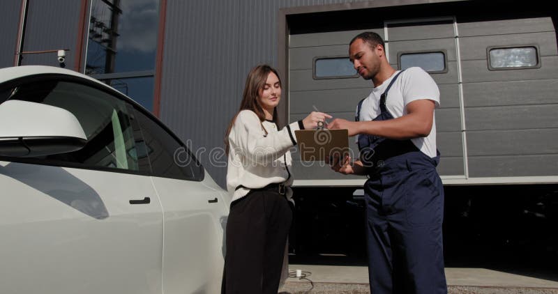 Female Customer Discussing Car Problem with Mechanic Outside Workshop ...
