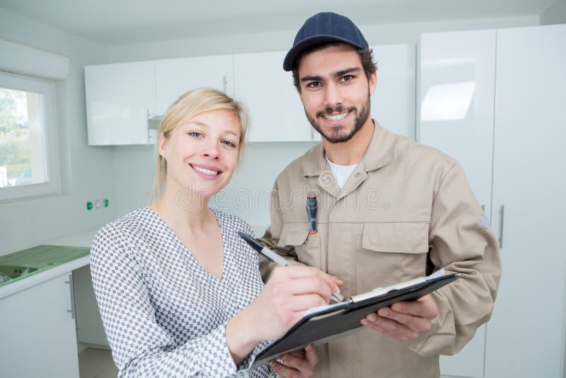 Female Customer Signing Tradesmans Clipboard Stock Photo - Image of ...