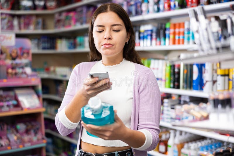 Female Customer Takes a Photo Using a Mobile Phone in Cosmetics Store ...