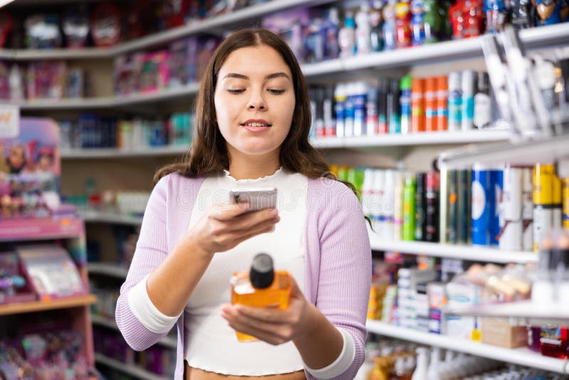 Female Customer Takes a Photo Using a Mobile Phone in Cosmetics Store ...