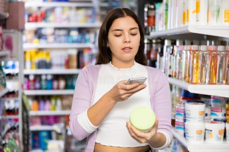 Female Customer Takes a Photo Using a Mobile Phone in Cosmetics Store ...