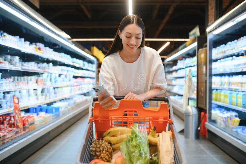 Female Customer Uses Mobile Phone in Supermarket Stock Photo - Image of ...