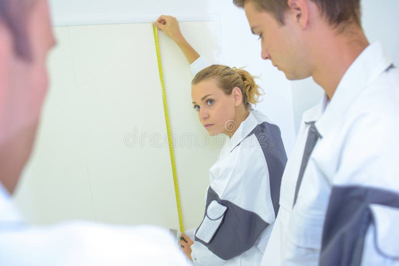 Female Decorator Measuring Wall Stock Image - Image of renewal, room ...