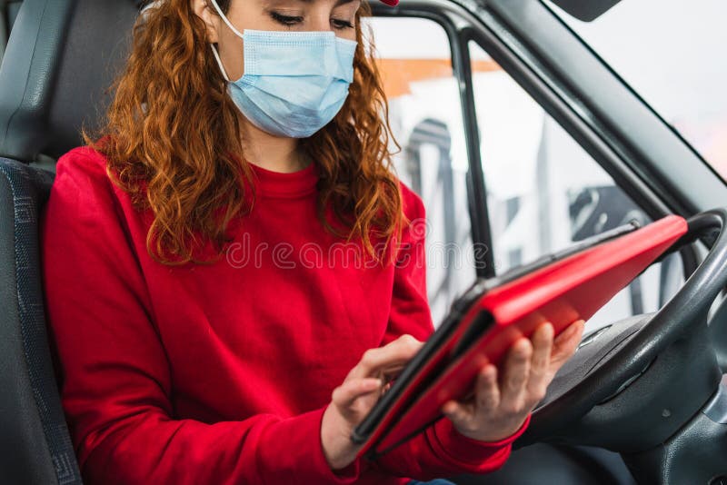 Female Delivery Driver with a Medical Mask Tracking a Package on Her ...
