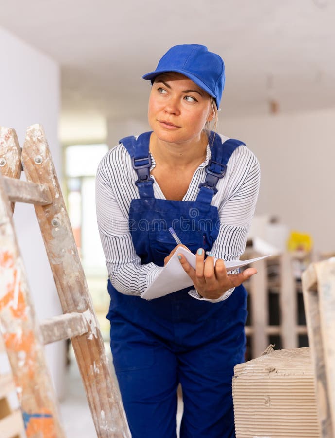 Female Designer in Blue Overalls Making Checklist while Planning ...