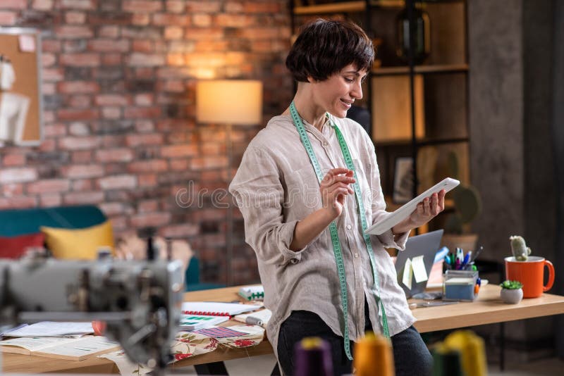 Female Designer of Clothes Standing by Sewing Machine in Atelier ...