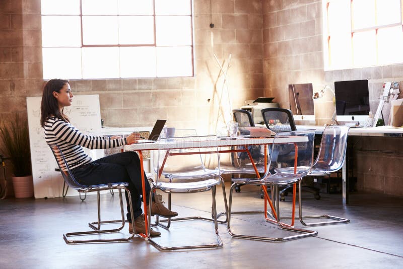 Female Designer Sitting at Meeting Table Working on Laptop Stock Photo ...